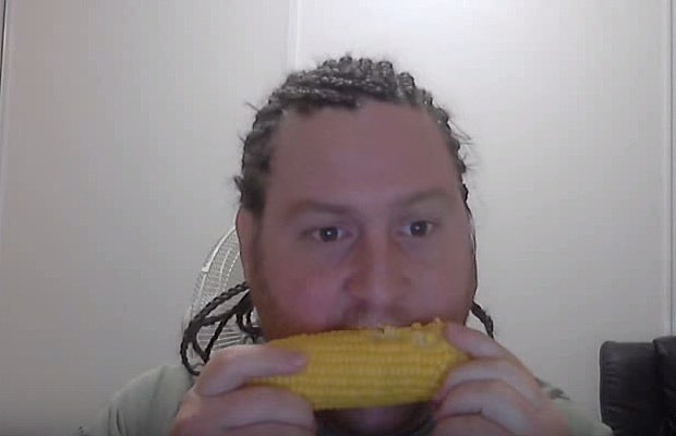 Guy with cornrows listens to Korn while eating corn